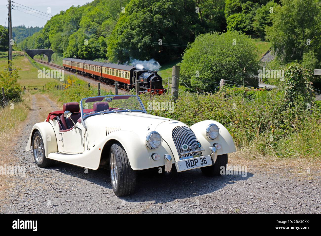Steam Train and coaches with a Morgan 4/4 Sports Car alongside the ...