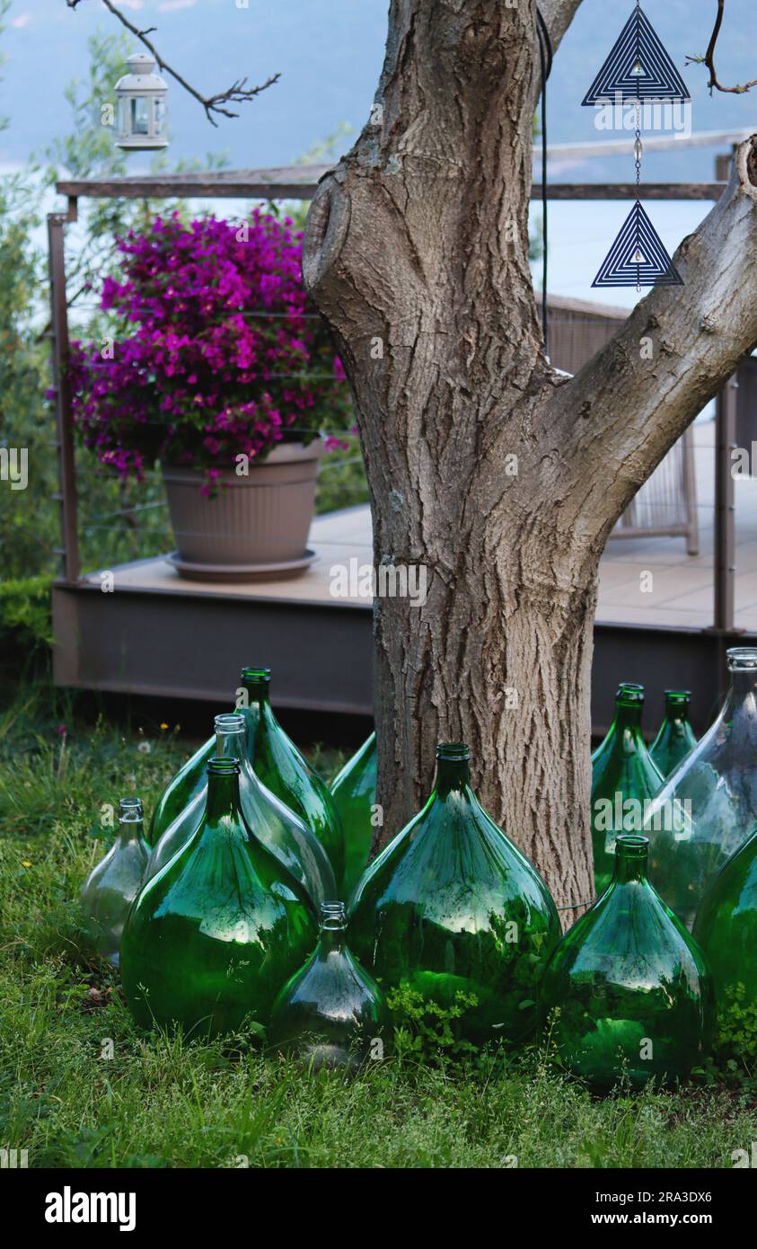 Huge wine bottles for storing wine at the winery garden. Set of ...