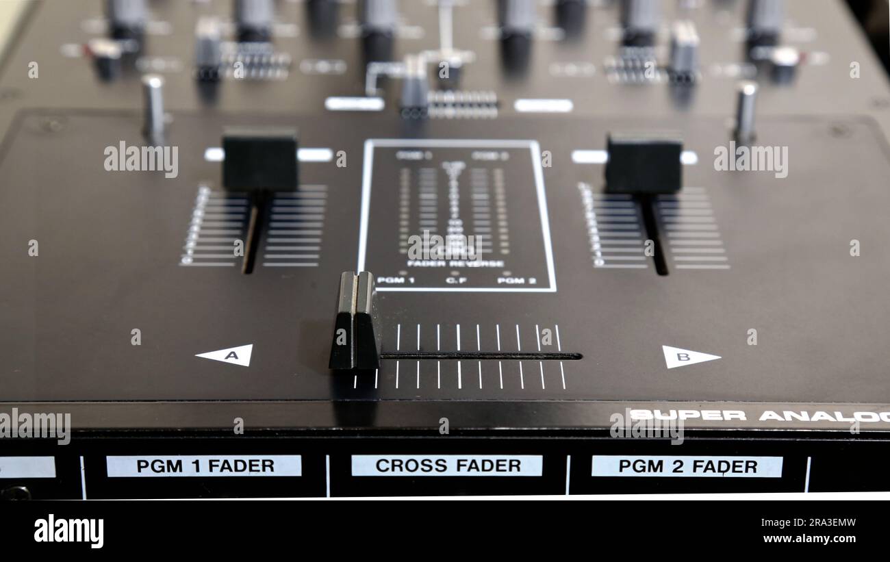 DJ mixer close up with hand (super analog with crossfader) volume knobs ...