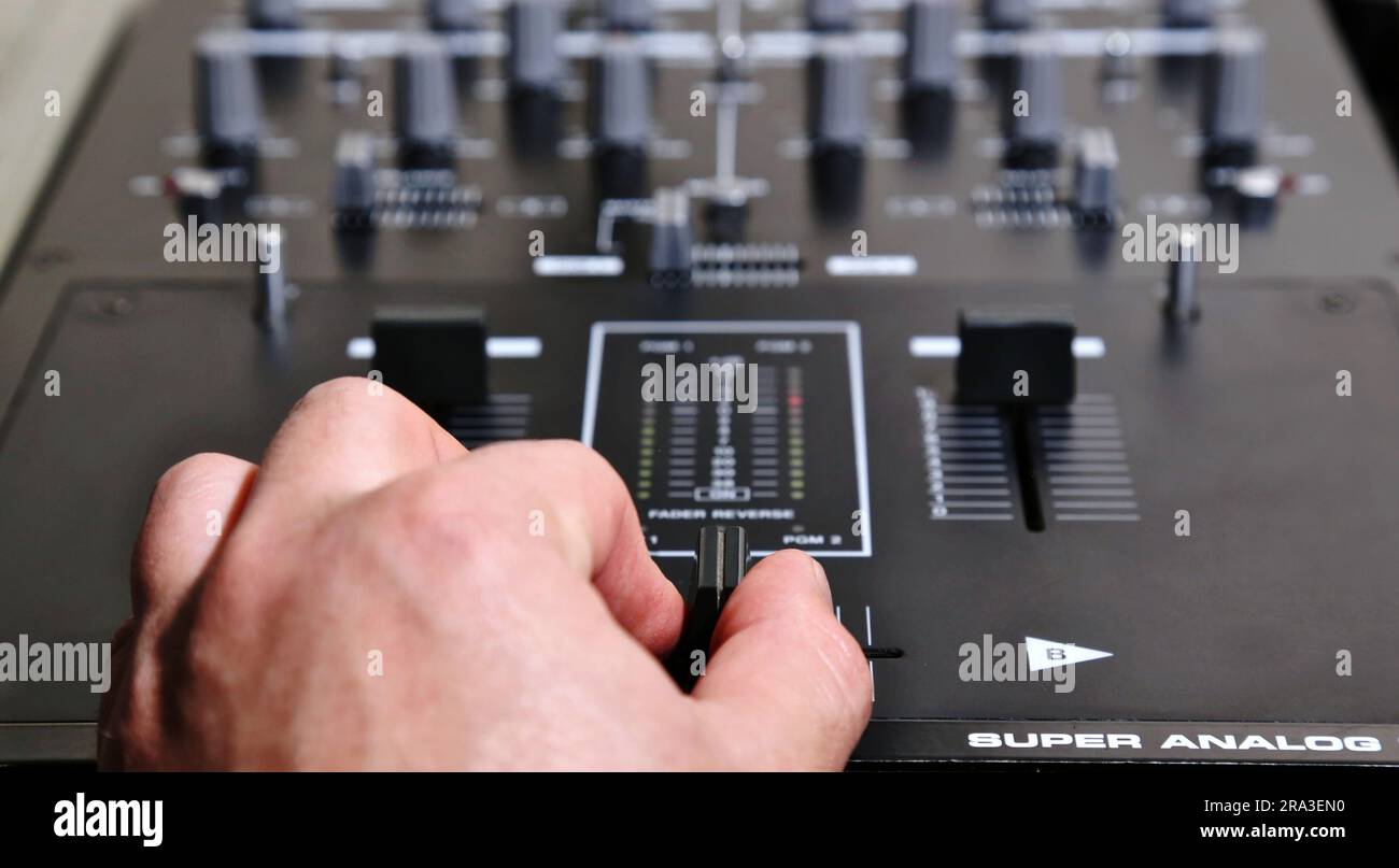 DJ mixer close up with hand (super analog with crossfader) volume knobs ...