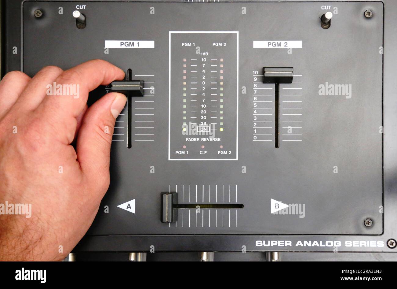 DJ mixer close up with hand (super analog with crossfader) volume knobs ...