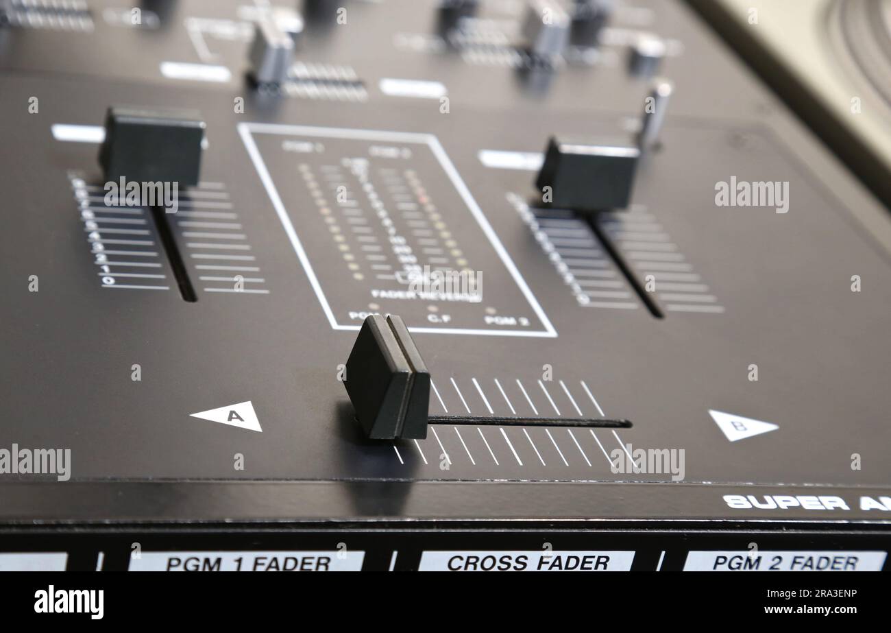 DJ mixer close up with hand (super analog with crossfader) volume knobs ...