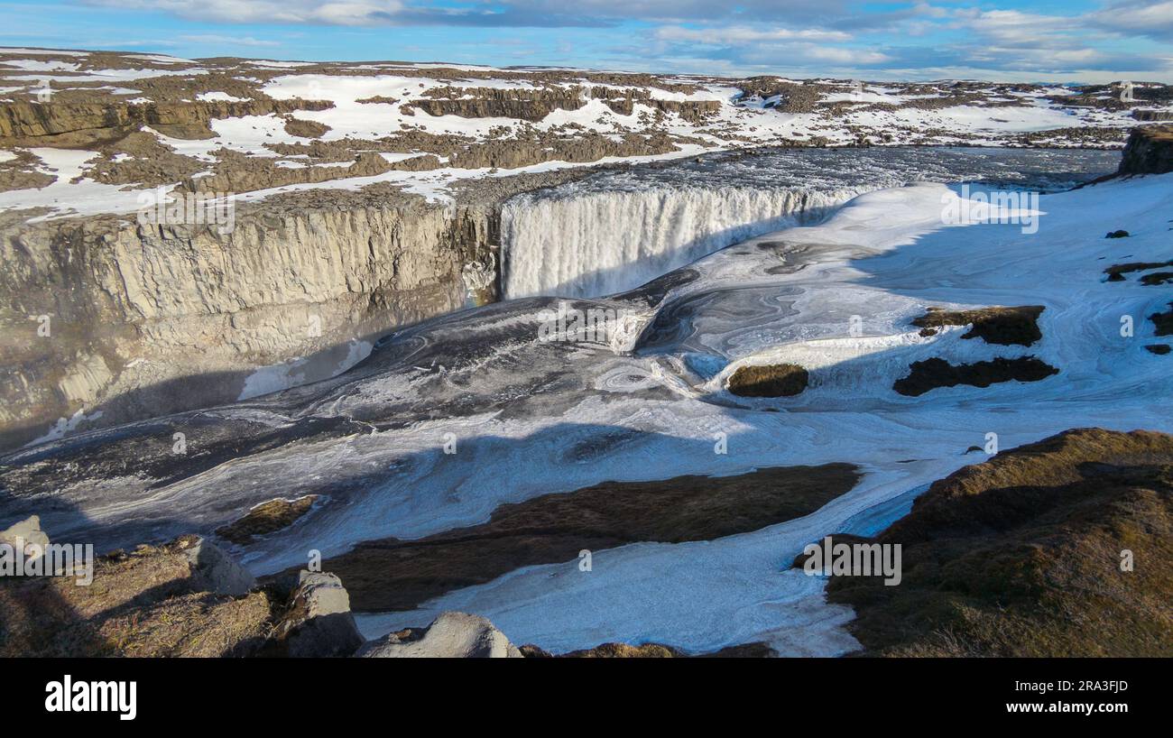 A beautiful, majestic ice waterfall cascading down a rocky cliff face ...