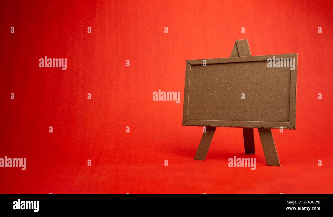 A blank brown wooden blackboard on an easel on a red background Stock ...