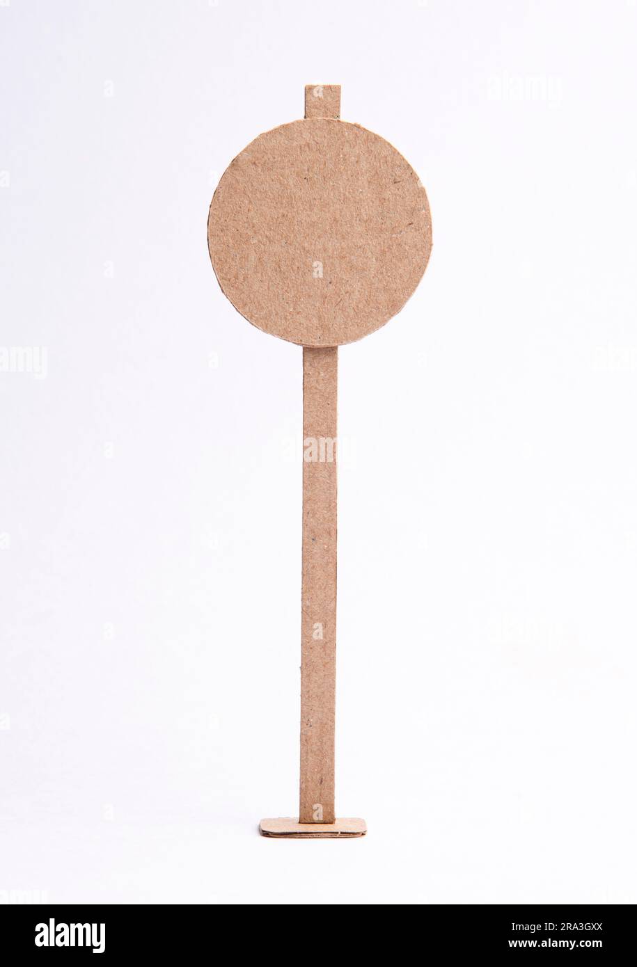 A brown cardboard cutout shaped like a sign on a pole isolated on a ...