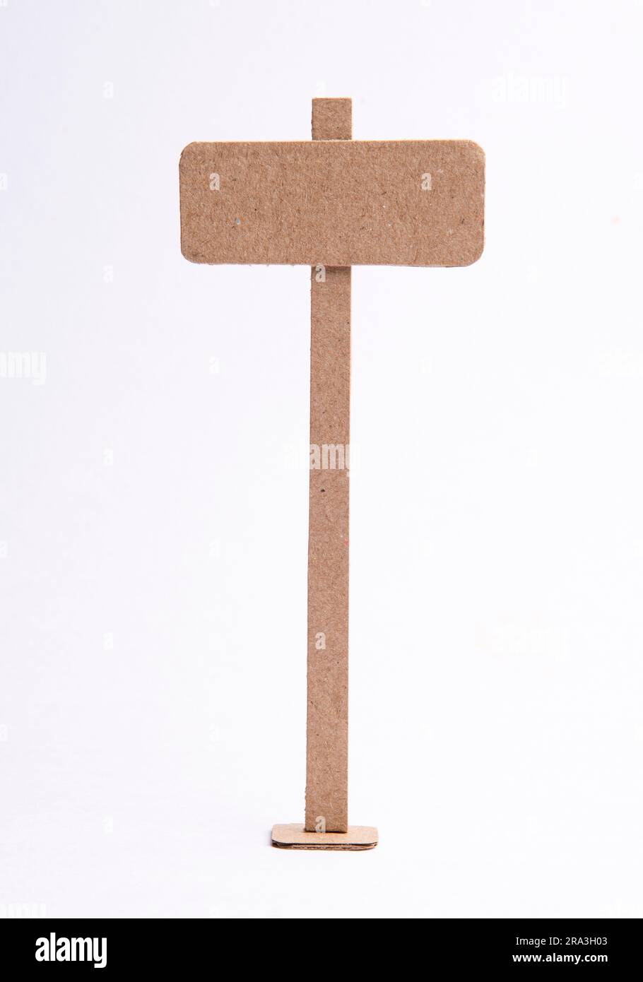A brown cardboard cutout shaped like a sign on a pole isolated on a ...