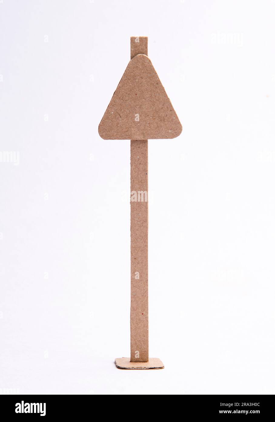 A brown cardboard cutout shaped like a sign on a pole isolated on a ...