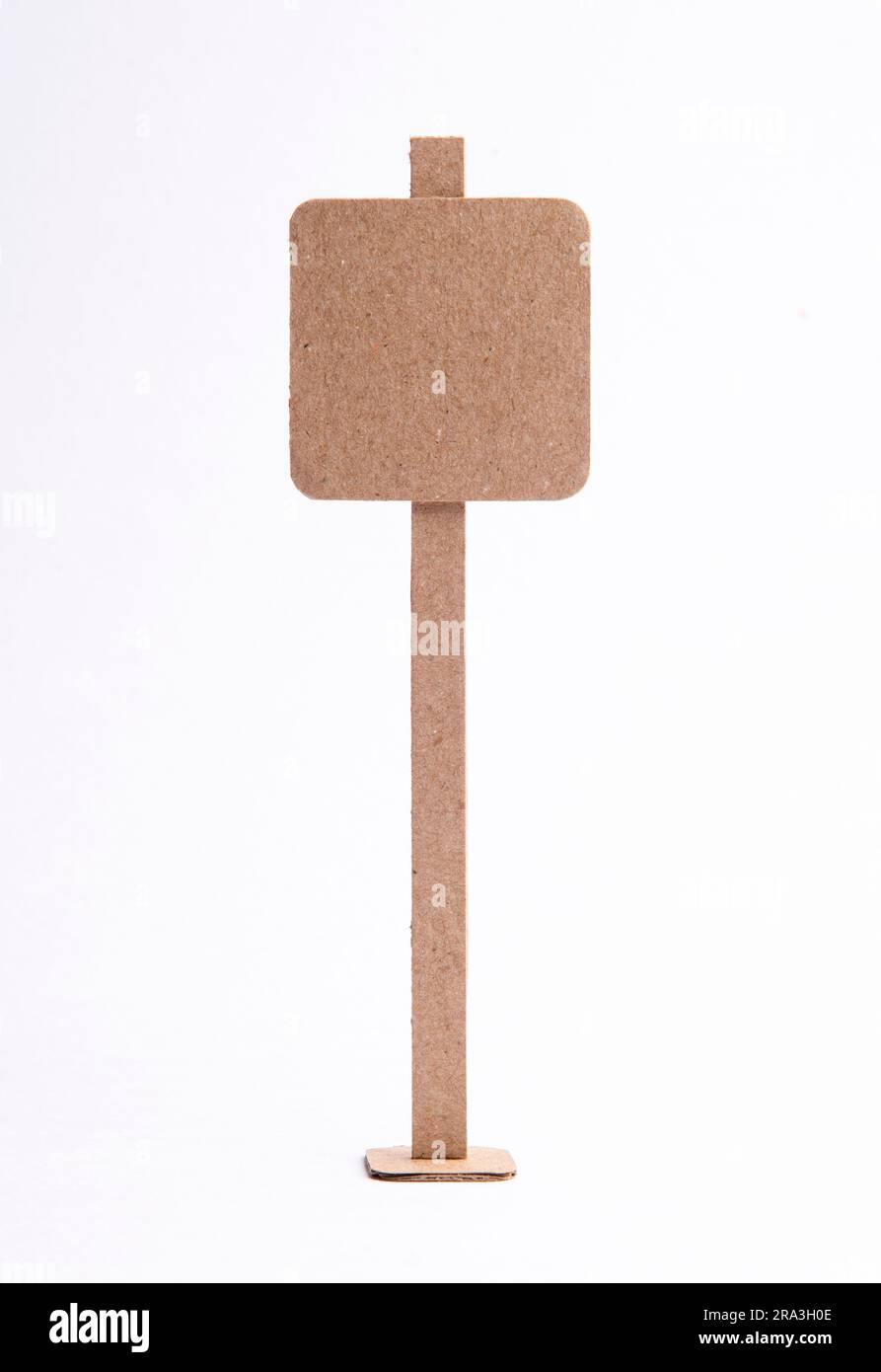 A brown cardboard cutout shaped like a sign on a pole isolated on a ...