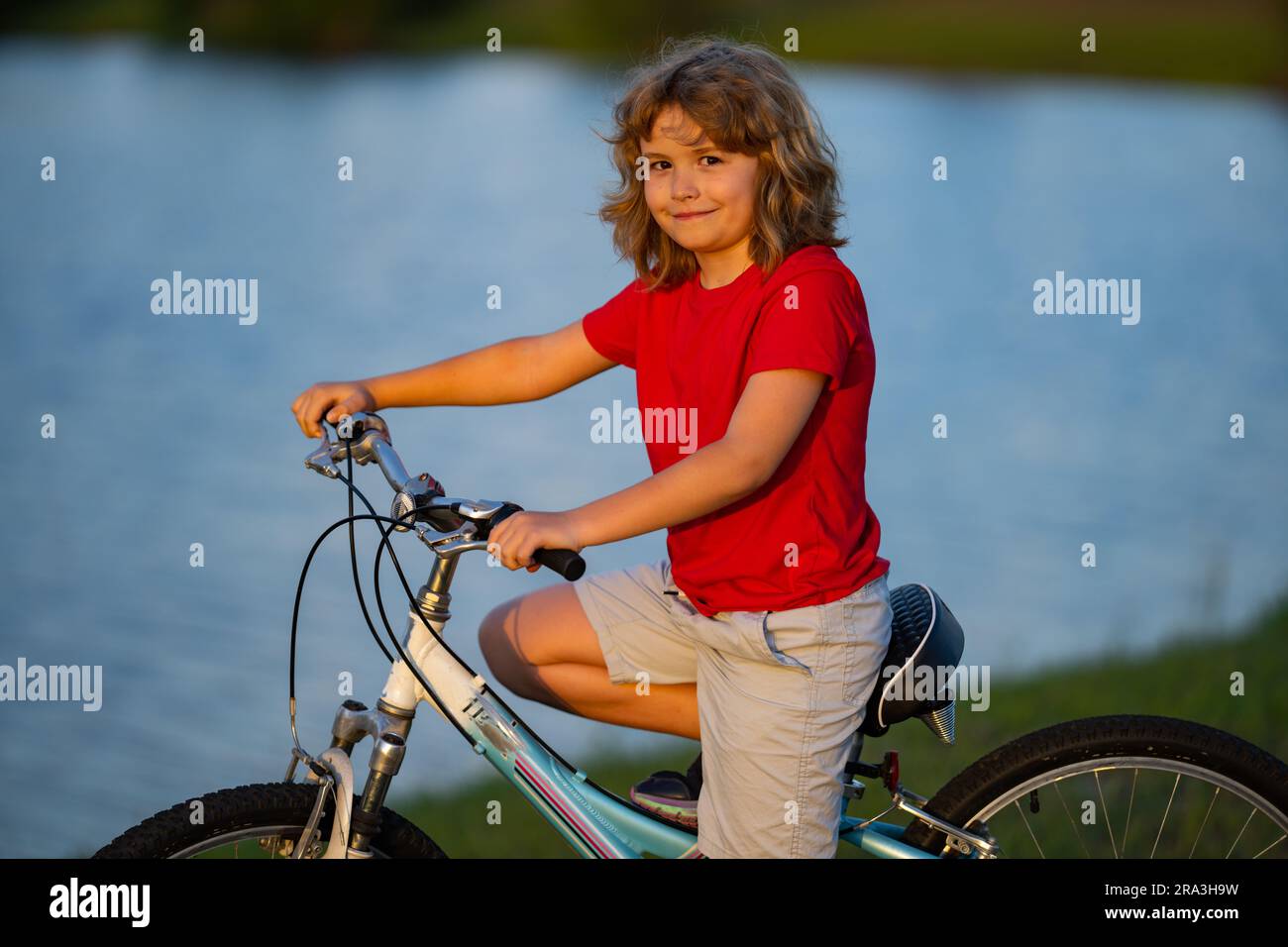 Child riding bicycle. Little kid boy on bicycle along bikeway. Happy ...