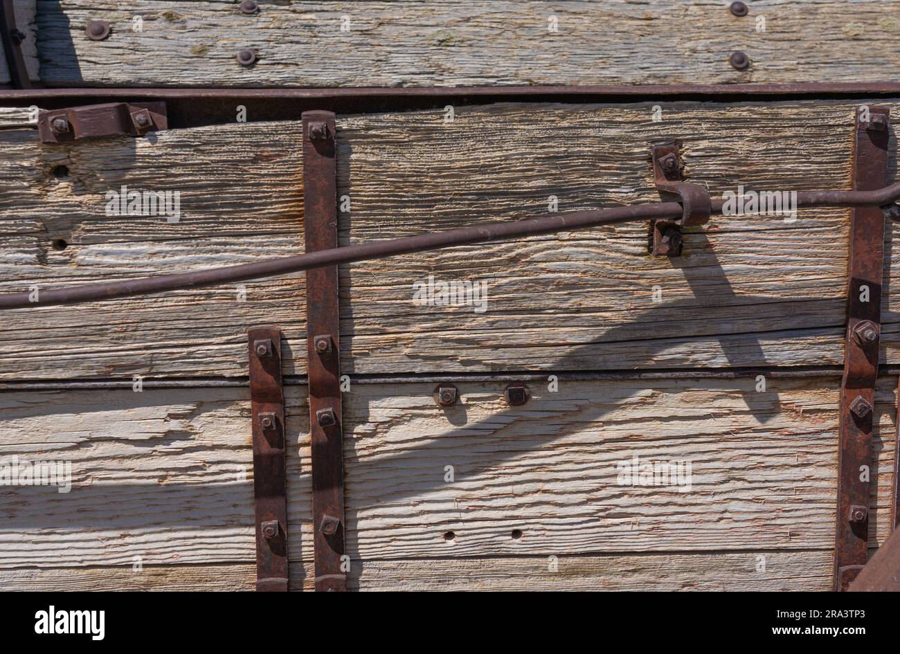 Rusted iron with rivets & bolts holds old weathered wood slabs together ...
