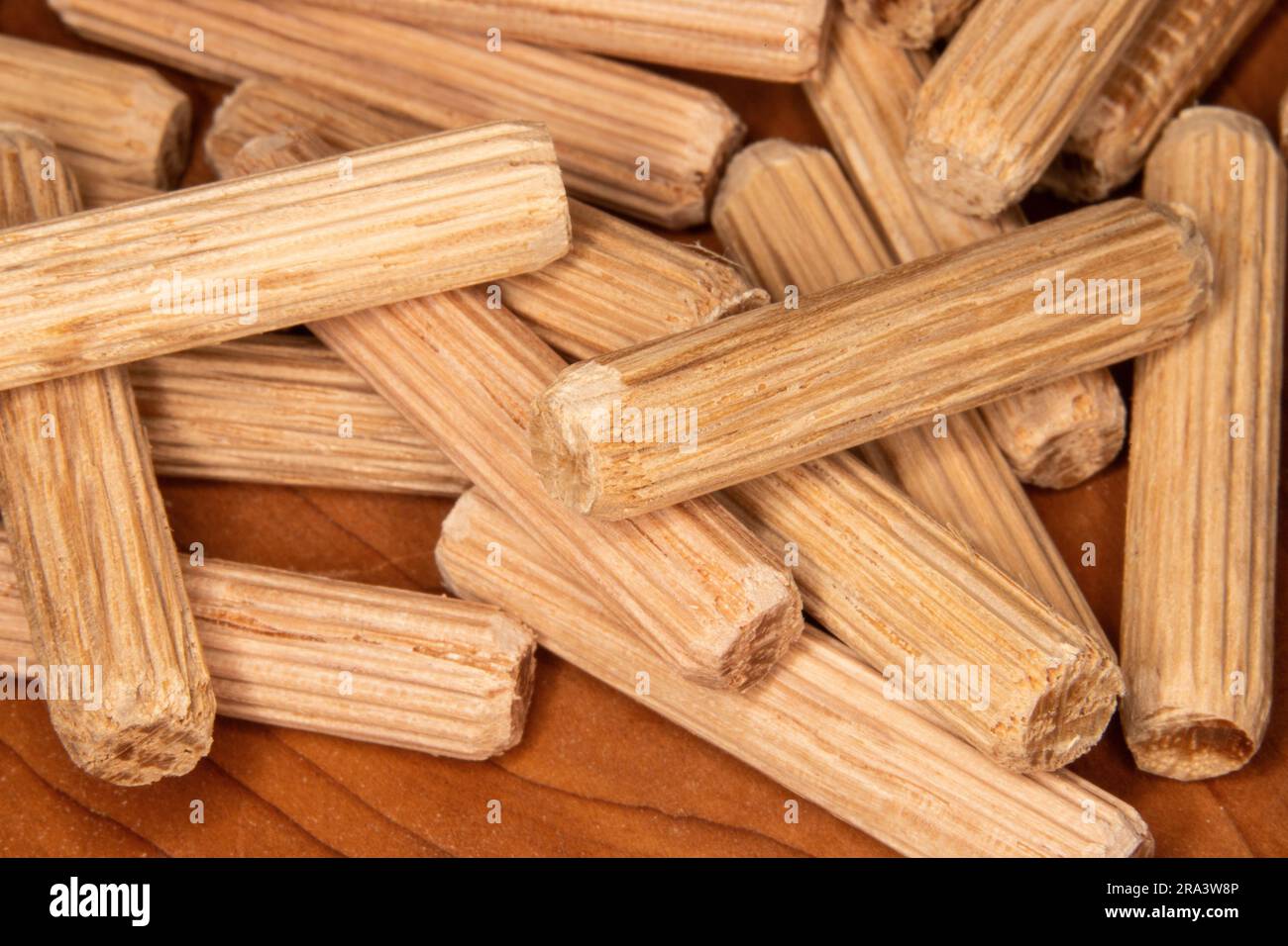 pile of oak dowel pins on cedar background, dowel pins used to join two ...