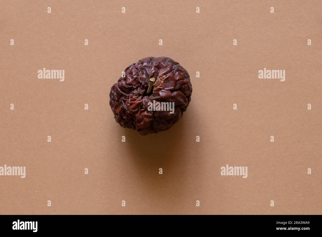 rotten red apple lies on a brown background close-up, rotten apple ...