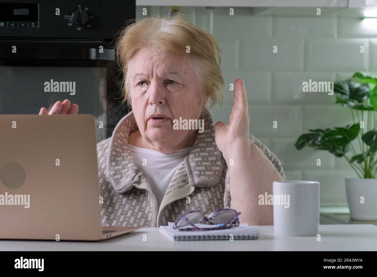 Shocked elderly woman at home looking at laptop seeing bad news Stock ...