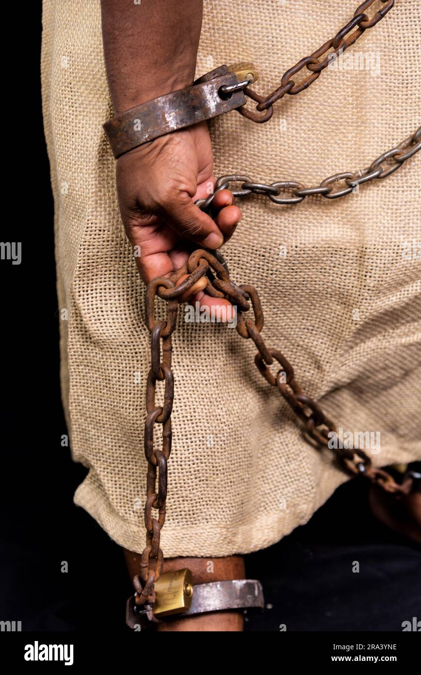 Black woman tied to old and rusty chains and with an iron mask on her ...