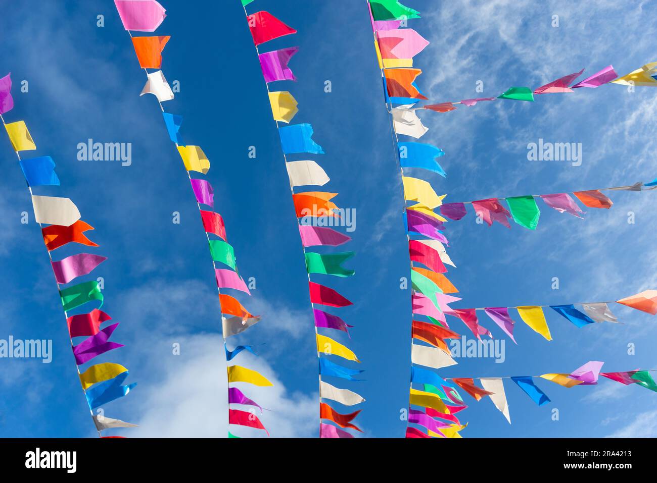 Flags of different colors hanging from a rope. Decoration of Sao Joao ...