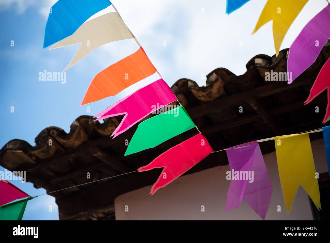 Flags of different colors hanging from a rope. Decoration of Sao Joao ...