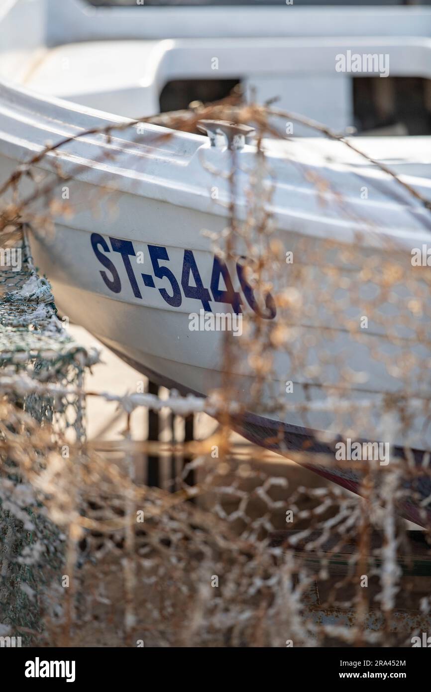 small inshore open fishing boat viewed through some fishermans nets ...