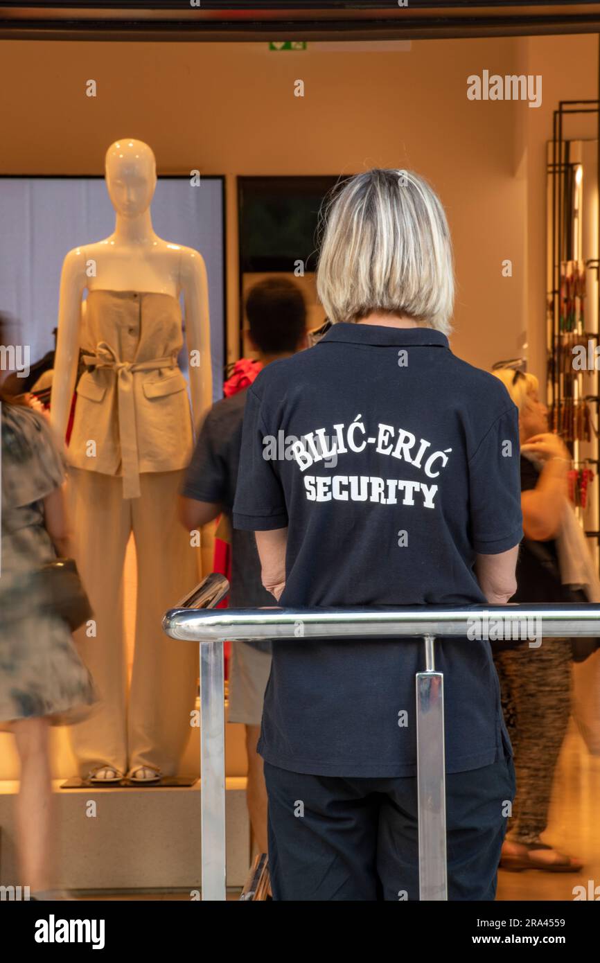 high street retailer security guard standing outside of a shop on guard ...