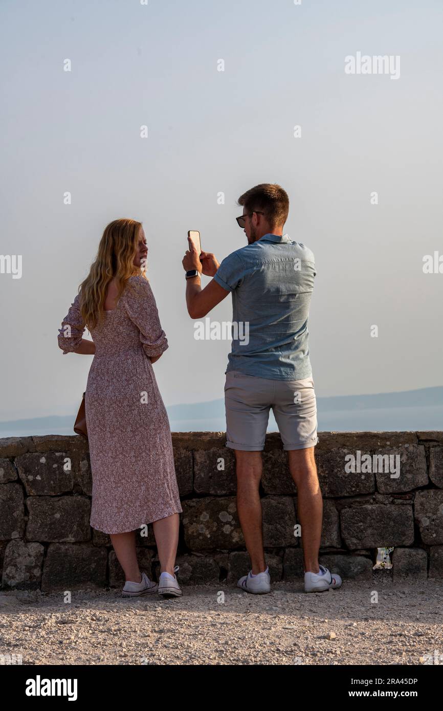 young couple taking holiday photos with a smartphone. boyfriend ...