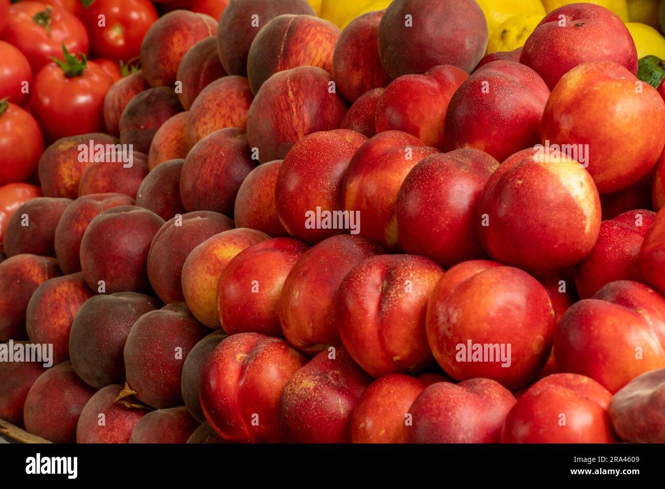 fresh peaches on display on a market stall selling fresh fruits and ...