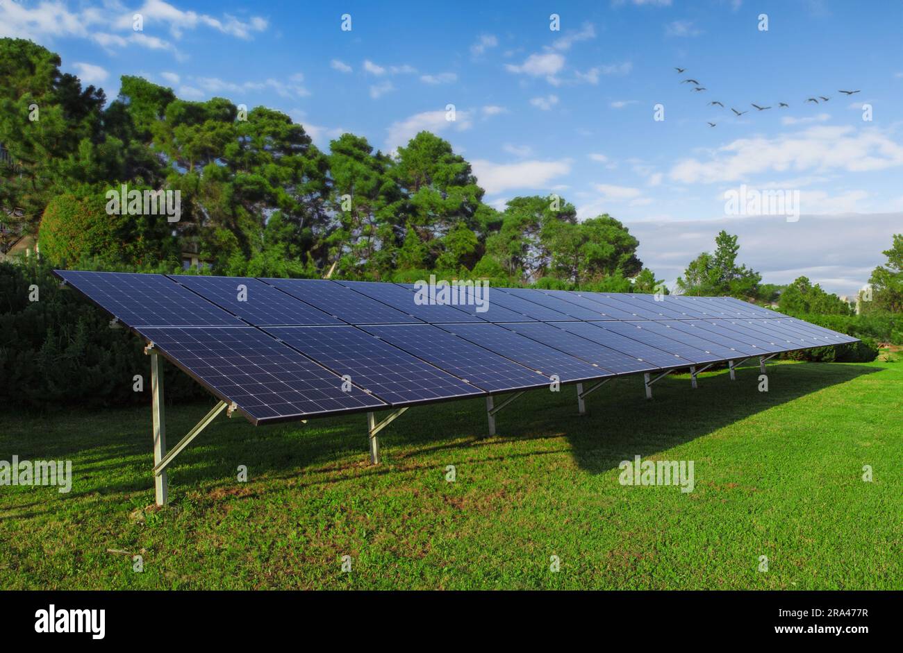 Photovoltaic installation, solar panels in the garden on the grass ...