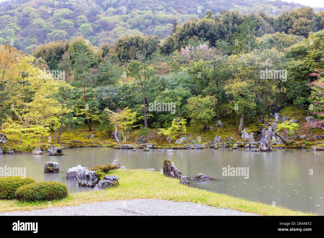 2023, Tenryu-ji Temple grounds and Sogenchi pond garden with Dragon Gate falls rocks on far side ...