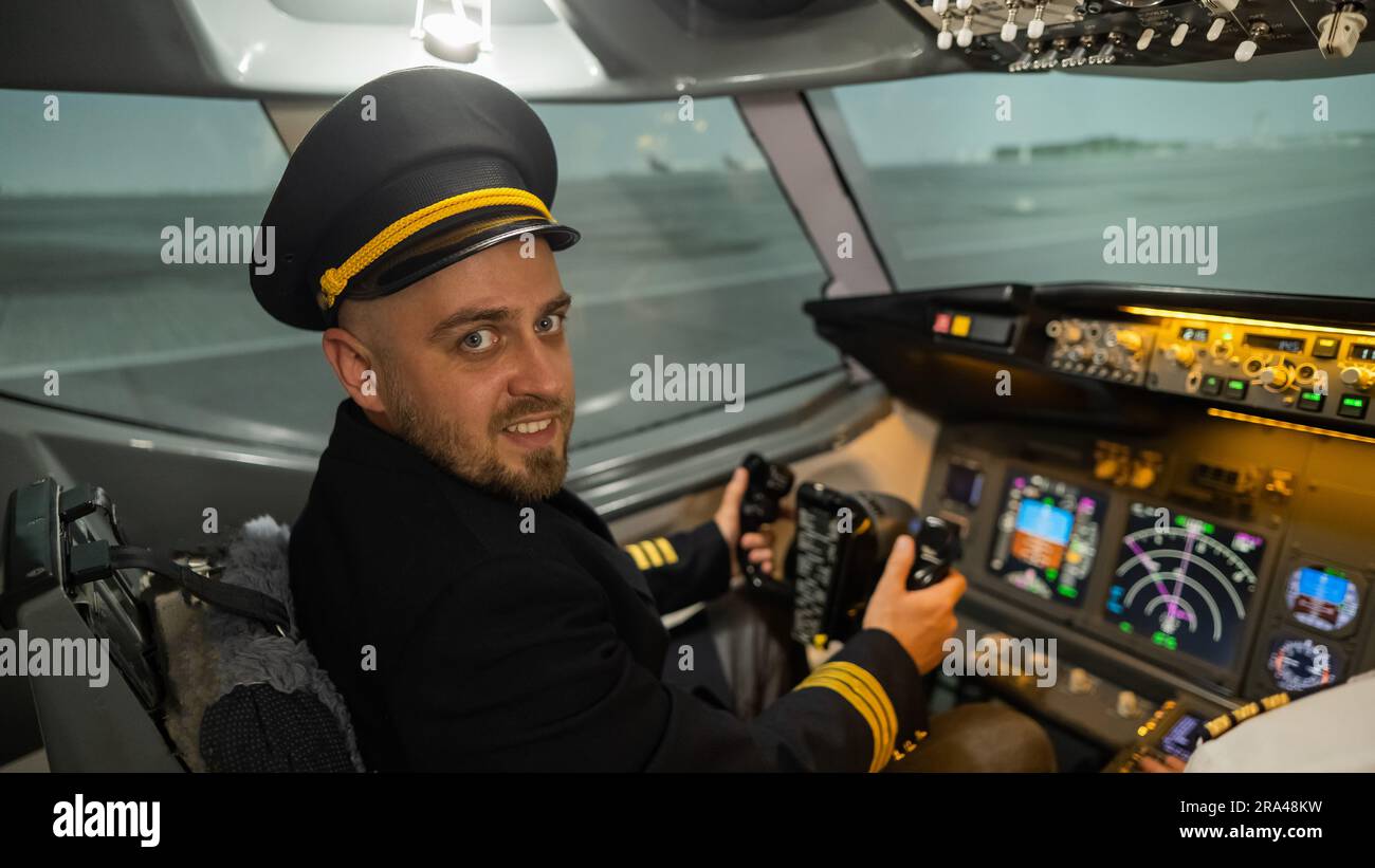 Caucasian bearded man smiling while sitting in a flight simulator ...