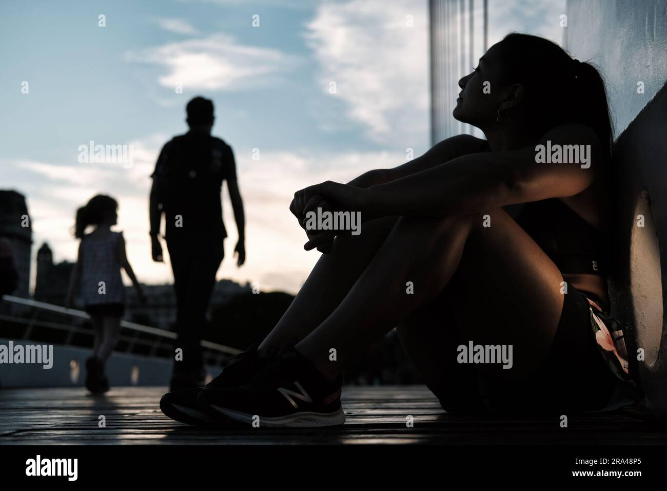 Subtly lit woman sitting silhouette Stock Photo - Alamy