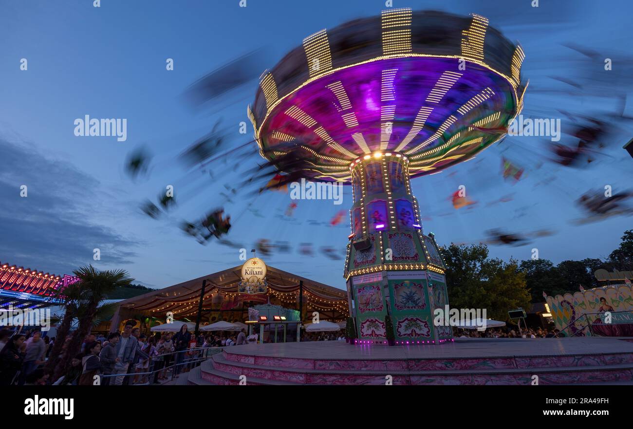 30 June 2023, Bavaria, Würzburg: Visitors ride the "Wellenflug" chain ...