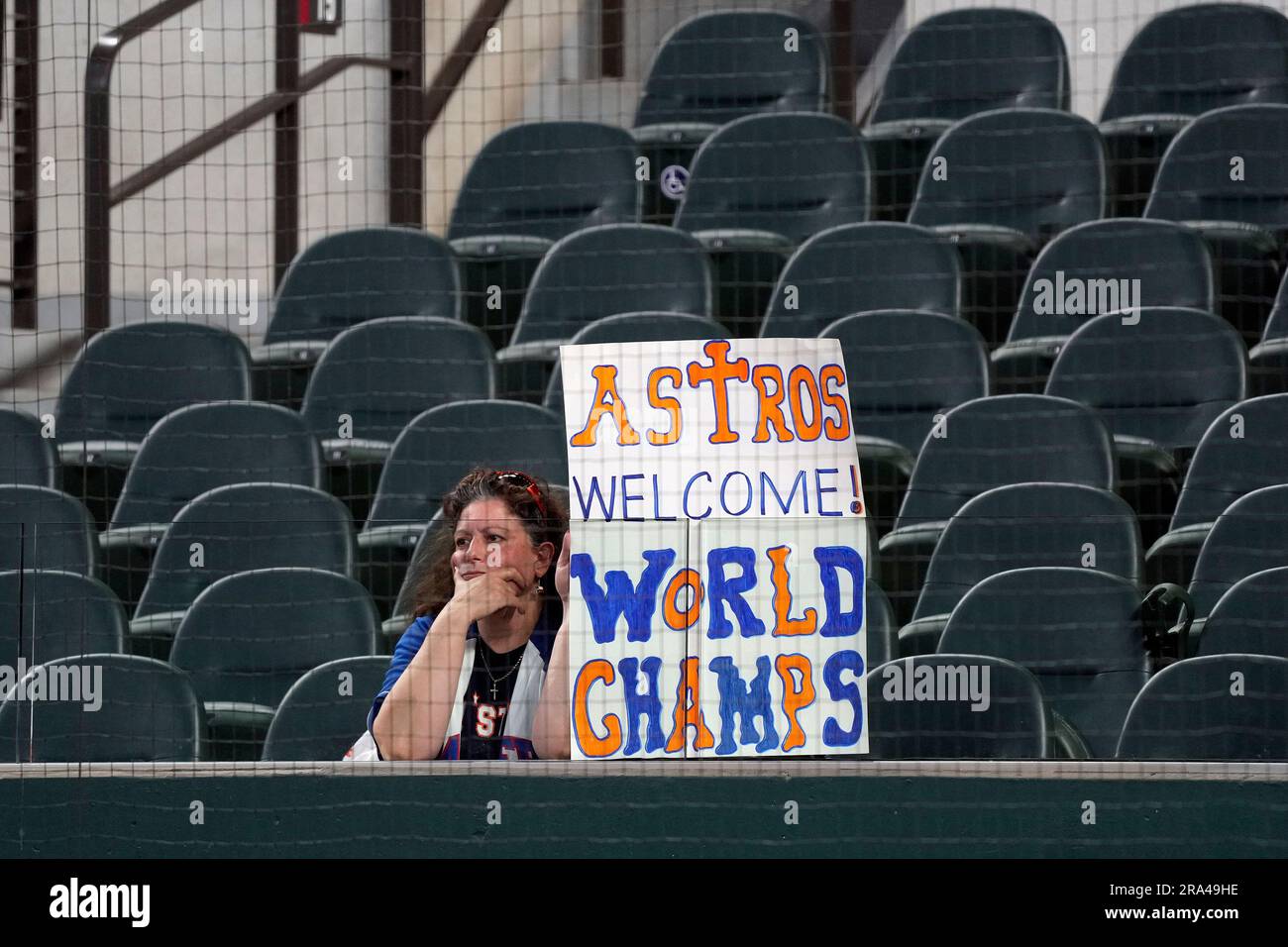 A Houston Astros fan in the stands holds a sign during warmups before a ...