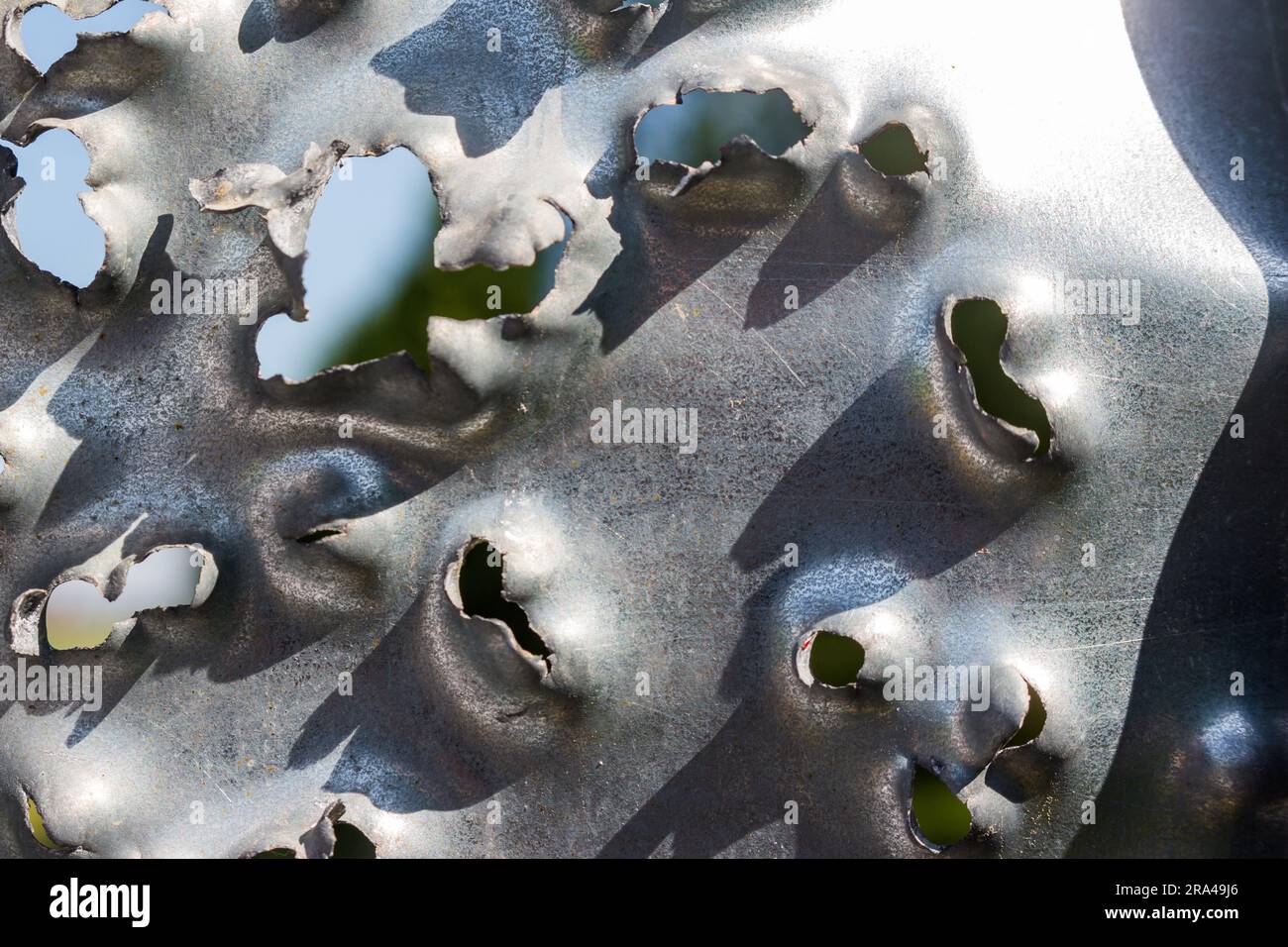 Exit bullet holes in metal from rifle shooting closeup Stock Photo - Alamy