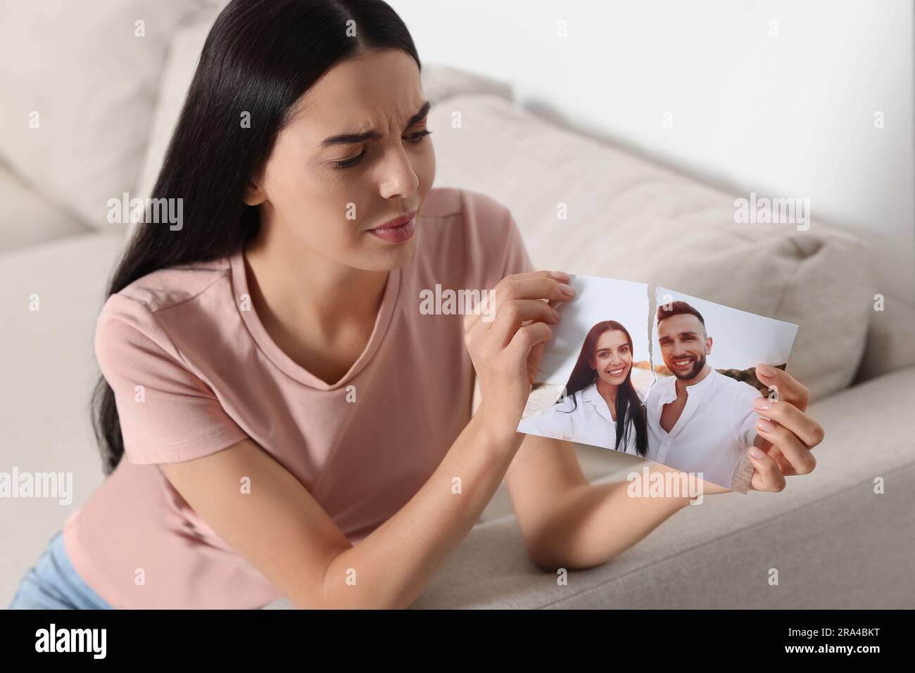 Upset woman ripping photo at home. Divorce concept Stock Photo - Alamy