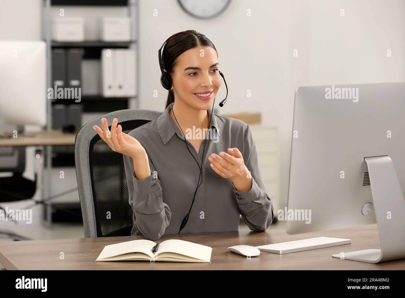 Hotline operator with headset working on computer in office Stock Photo ...