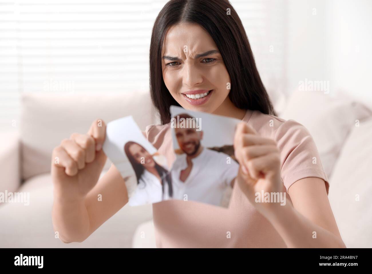 Upset woman ripping photo at home. Divorce concept Stock Photo - Alamy
