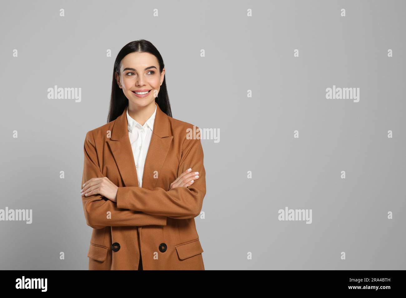 Beautiful real estate agent in nice suit on grey background, space for ...
