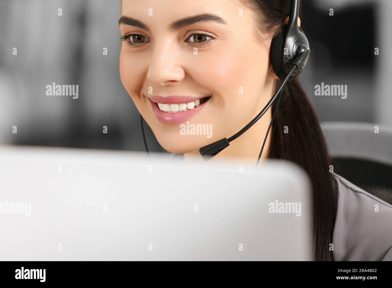 Hotline operator with headset working on computer in office Stock Photo ...