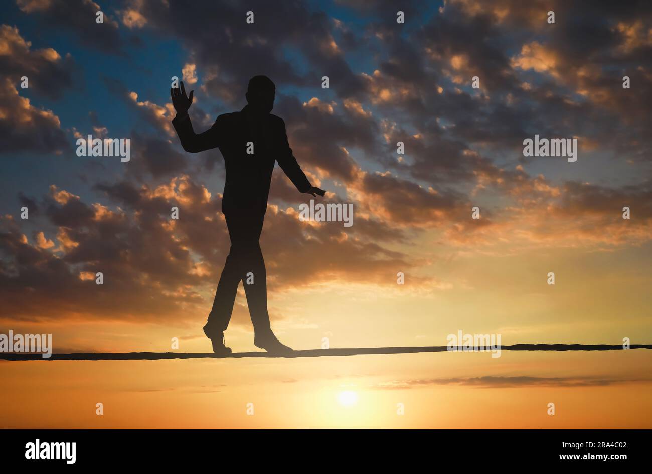 Risks and challenges of owning business. Silhouette of man balancing on ...