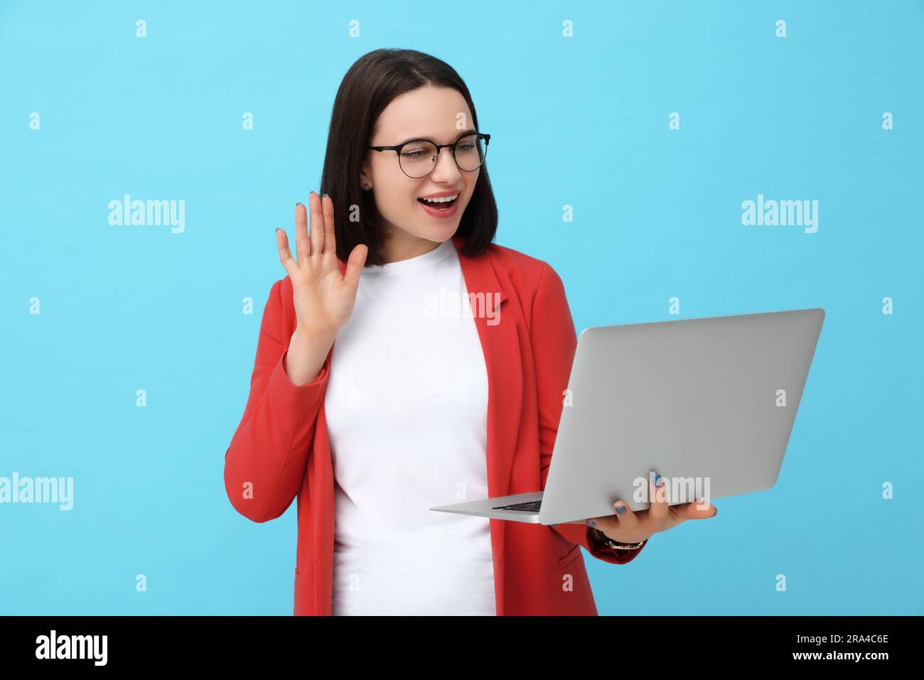 Happy young intern having online meeting on light blue background Stock ...