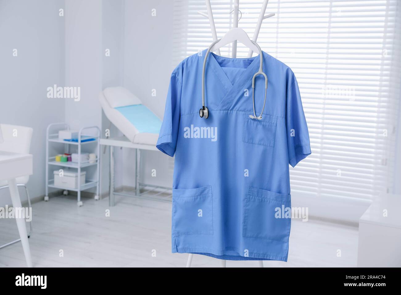 Blue medical uniform and stethoscope hanging on rack in clinic Stock ...