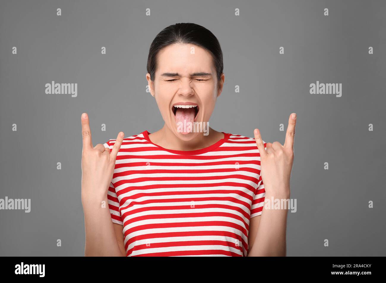Young woman making rock gesture hi-res stock photography and images - Alamy