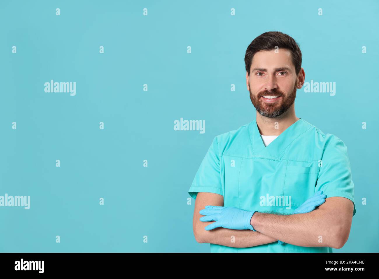 Happy nurse in medical uniform on light blue background, space for text ...