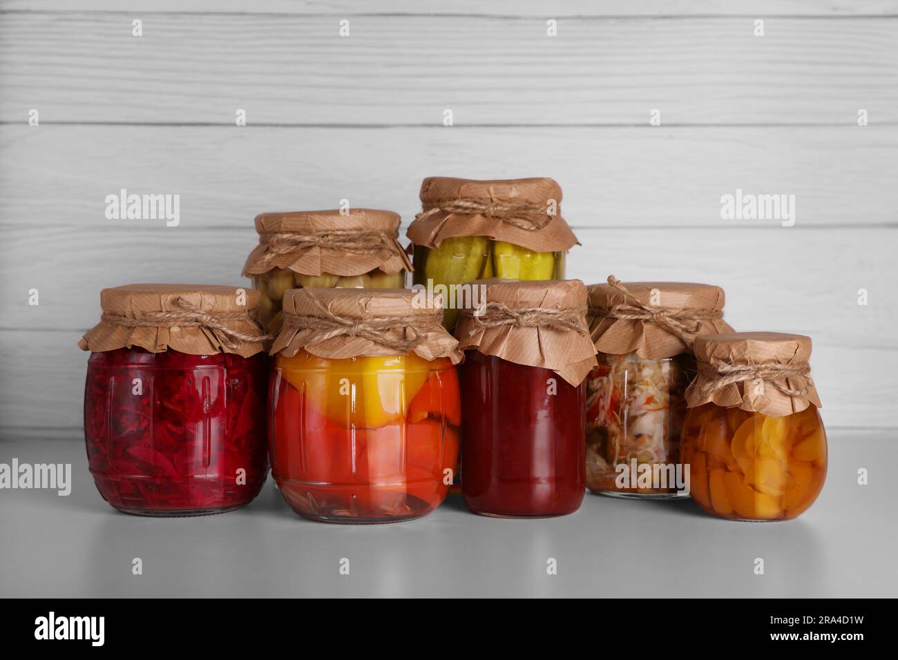 Many jars with different preserved products on light grey table Stock ...