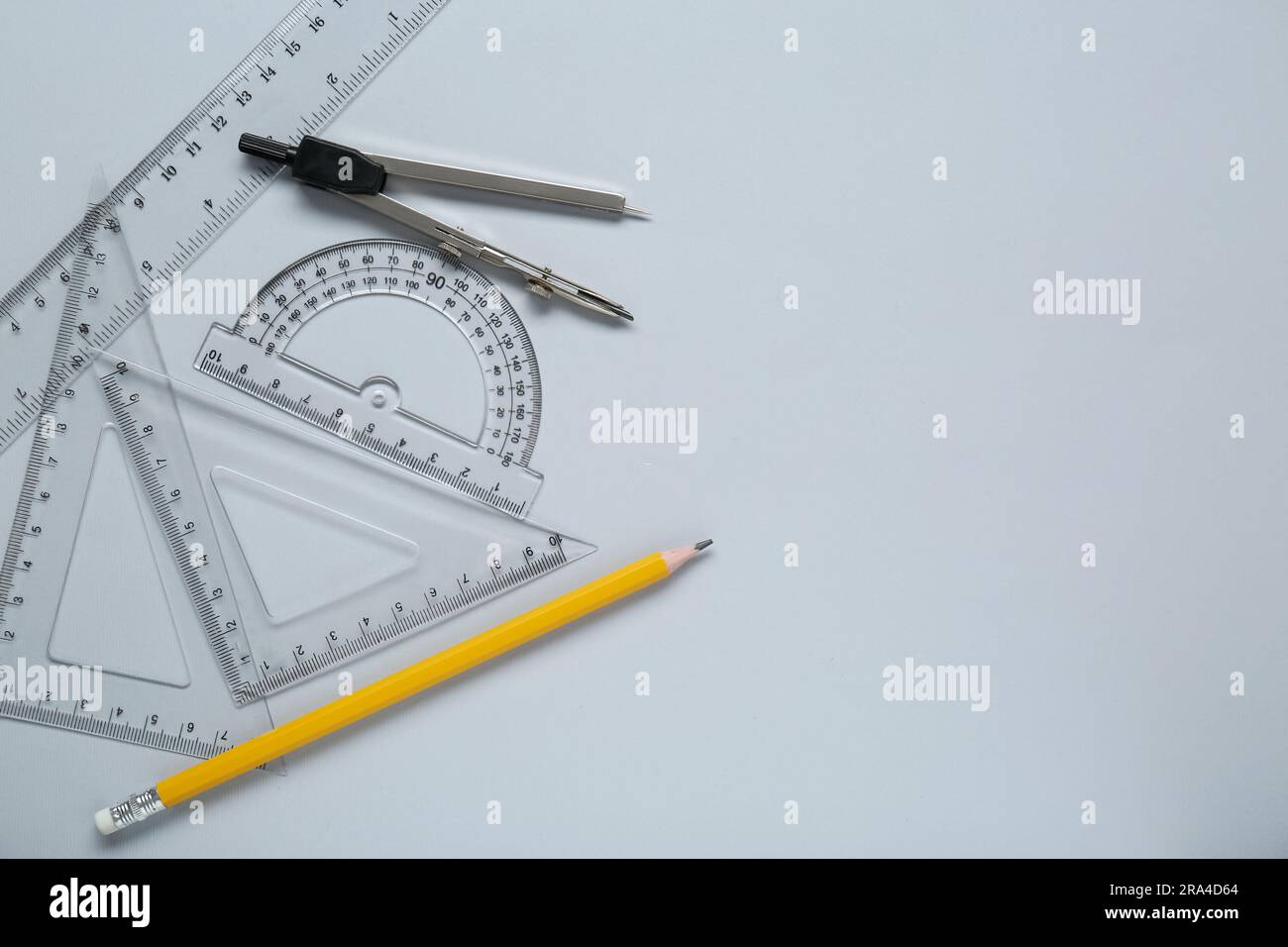 Different rulers and compass on light grey background, flat lay. Space ...