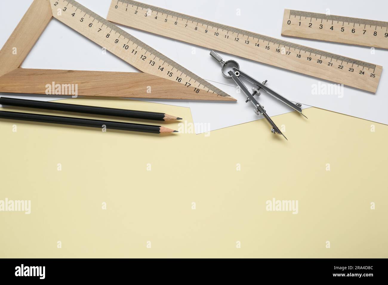 Different rulers, pencils and compass on yellow background, flat lay ...