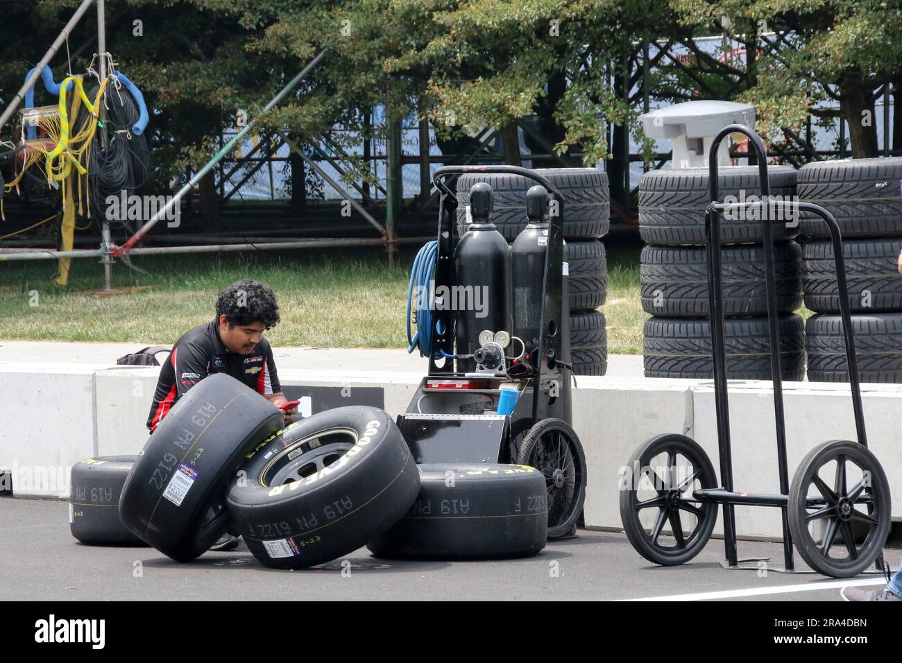 Pit crew workers move tires to prepare them for the the inaugural ...