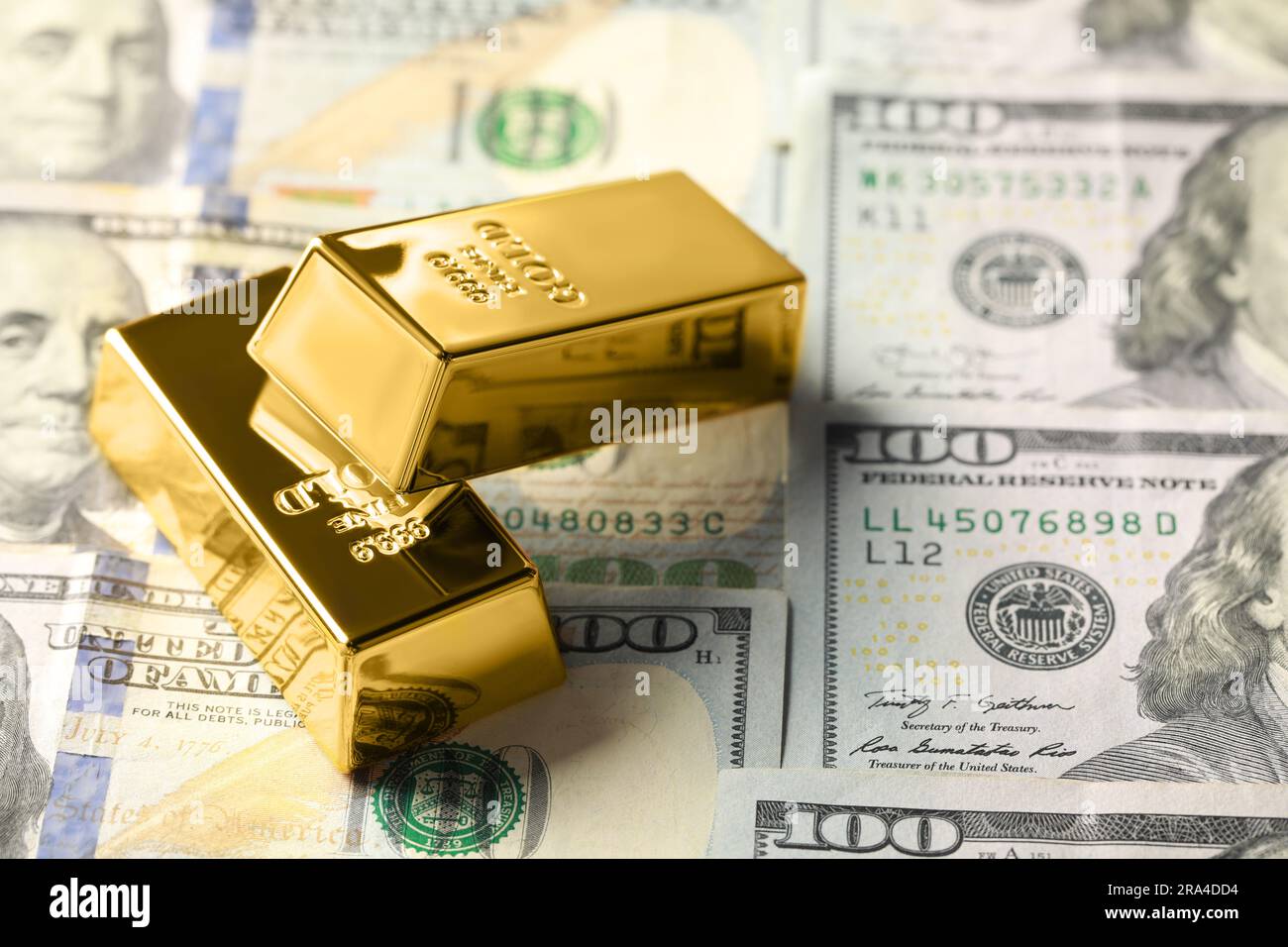 Shiny gold bars on dollar banknotes, closeup. Space for text Stock ...