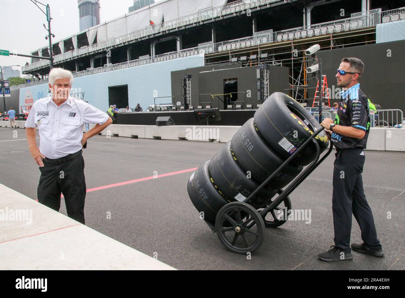 Pit crew workers move tires to prepare them for the the inaugural ...