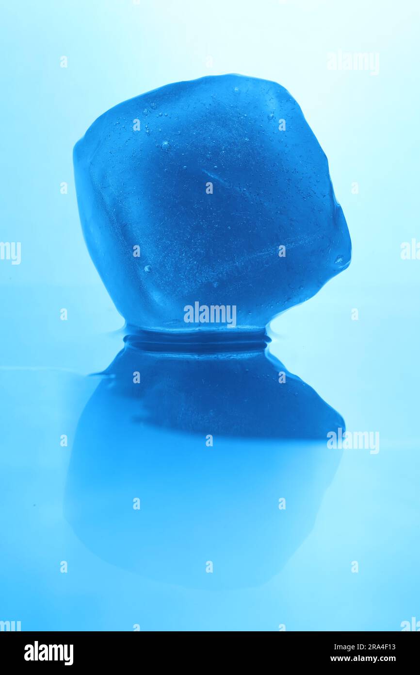 Crystal clear ice cube on light blue background, closeup. Color tone effect Stock Photo - Alamy