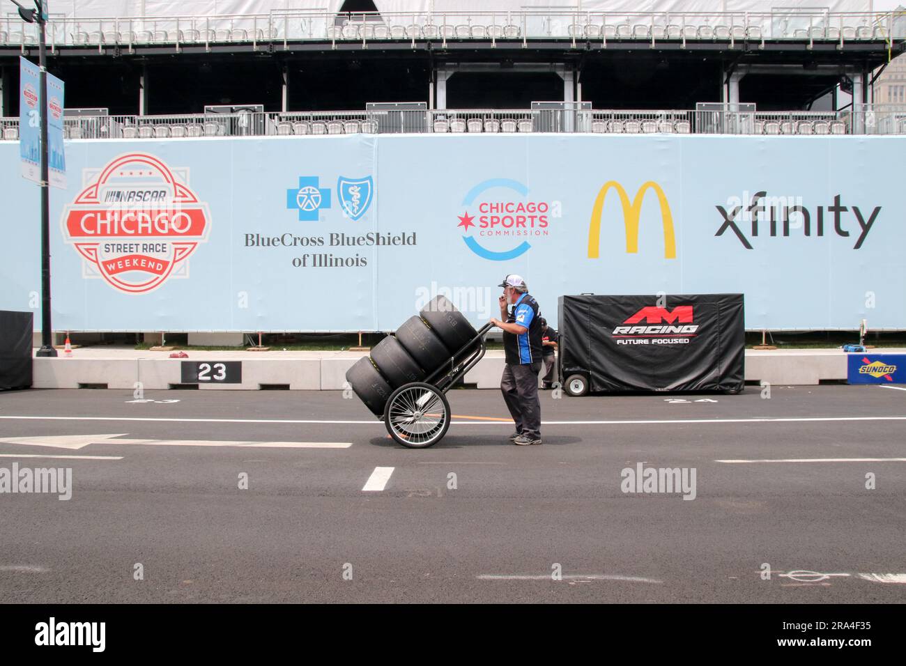 Pit crew workers move tires to prepare them for the inaugural NASCAR ...
