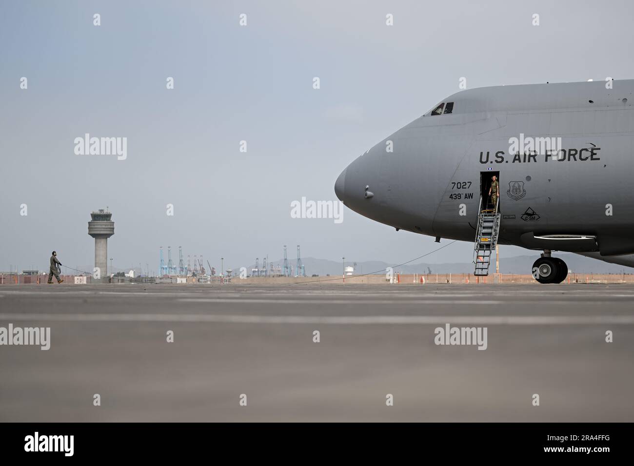A U.S. Air Force loadmaster prepares a C-5M Super Galaxy cargo aircraft ...